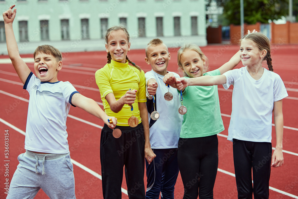 A boys and girls celebrating a victory. Motivated children team rising ...