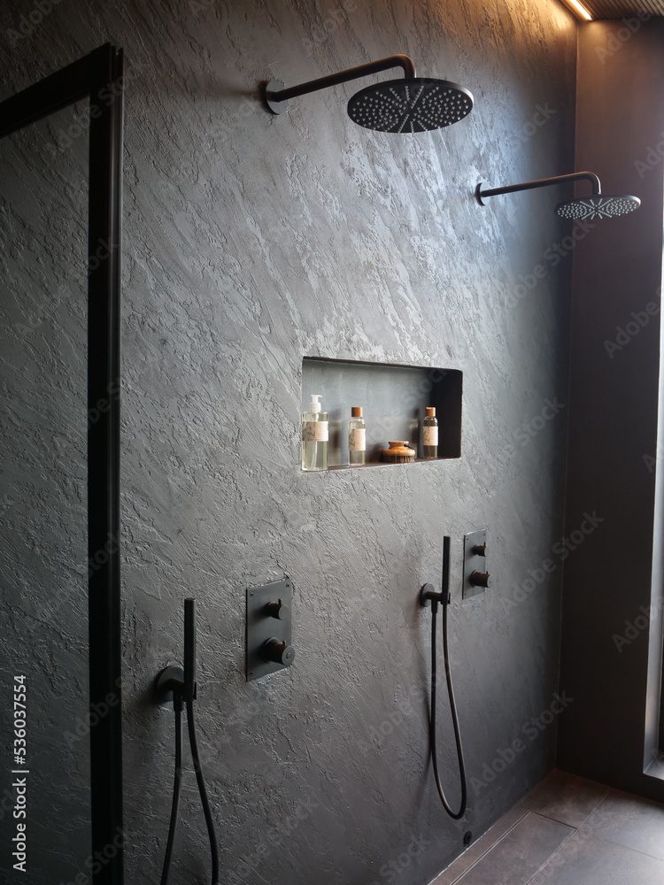 A modern dark shower room with a black stone wall at the Housing fair ...