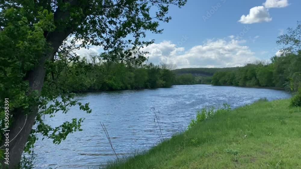 hot summer day with clouds and blue sky with flowing water way and wind ...