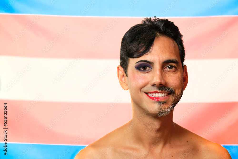 portrait of a trans man with half his face bearded and the other half ...