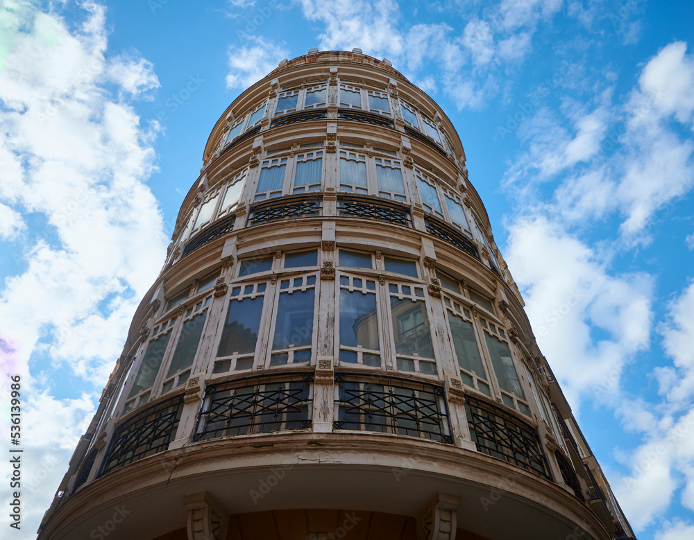 Building with circular corner and wooden windows. blue sky with clouds ...