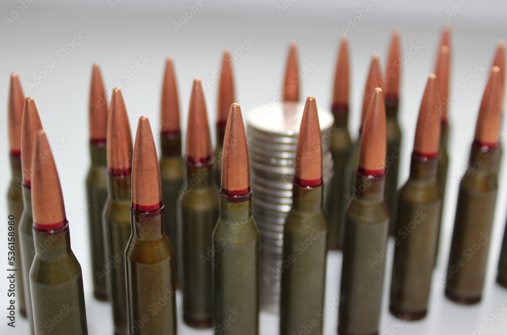 Rows of gun bullets with blurred coins column inside a rows stock photo ...