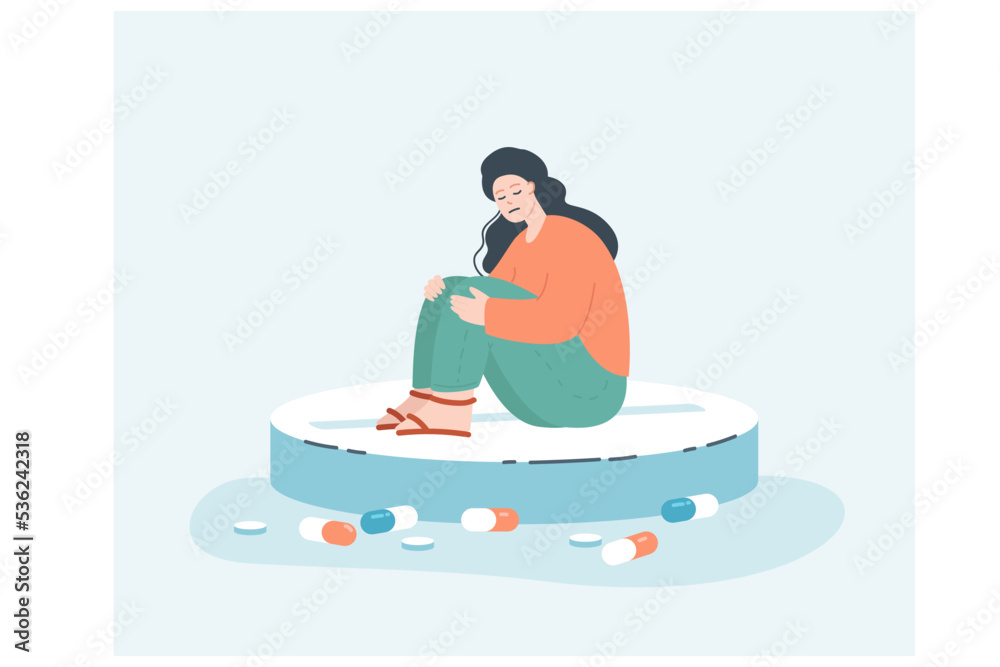 Depressed female addict sitting on giant pill. Sad girl taking ...