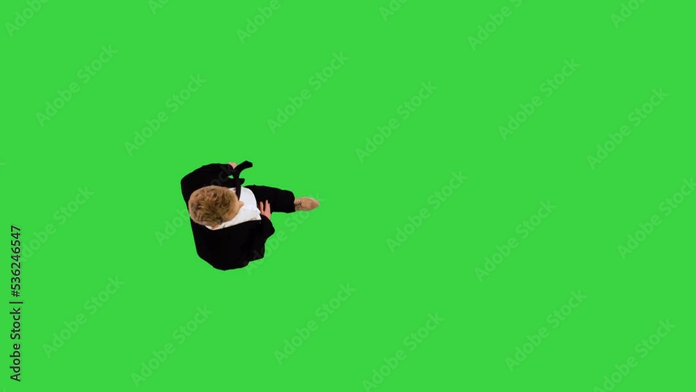 Handsome male dancer in office suit makes a back flip on his arm, turns ...