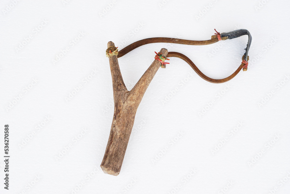 Handmade wooden slingshot, a Y-shaped stick with elastic between the ...