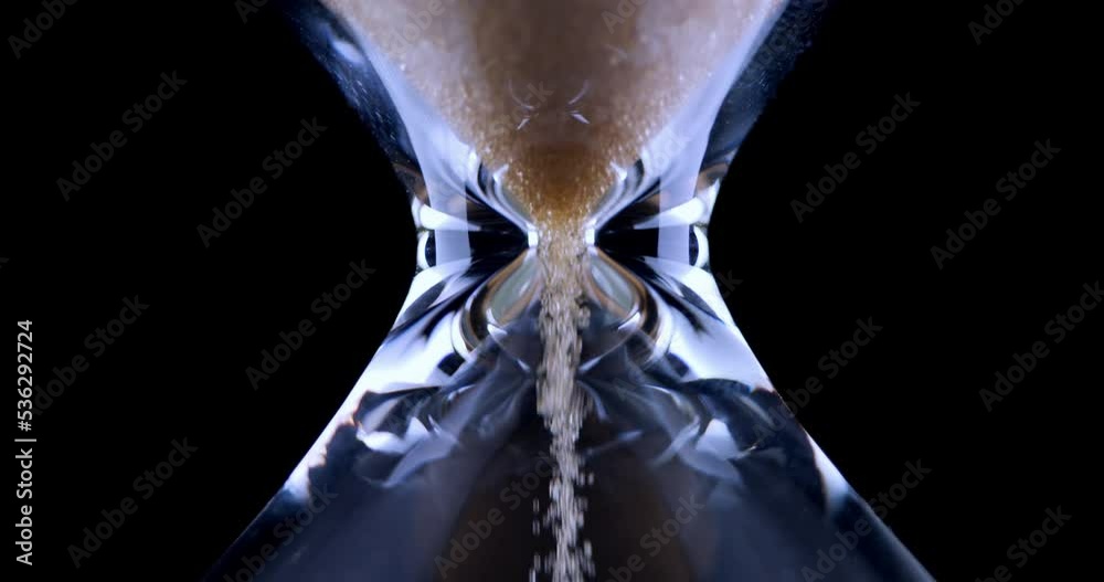 Hourglass. Sands move through hour glass. Sandglass close-up on a black ...