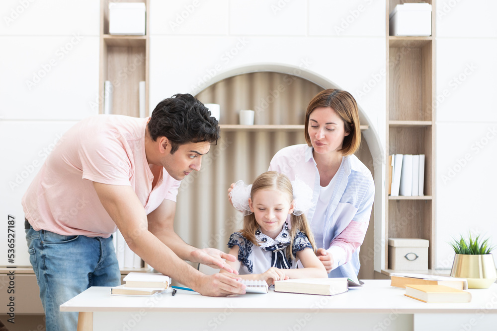 Parents helping their daughter with lessons and homework. Mother ...