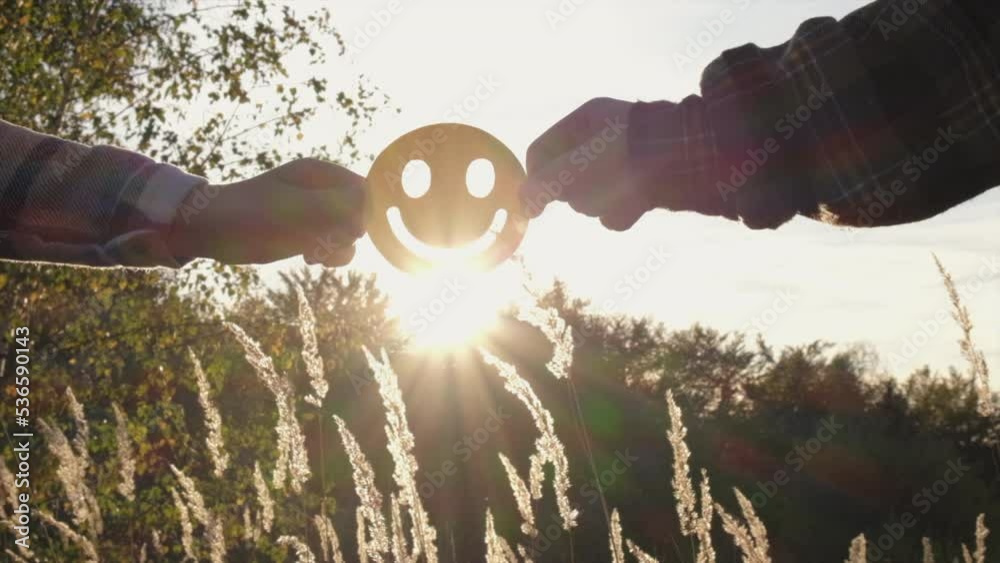 Close up of mother and daughter holding happy face emoticon on ...