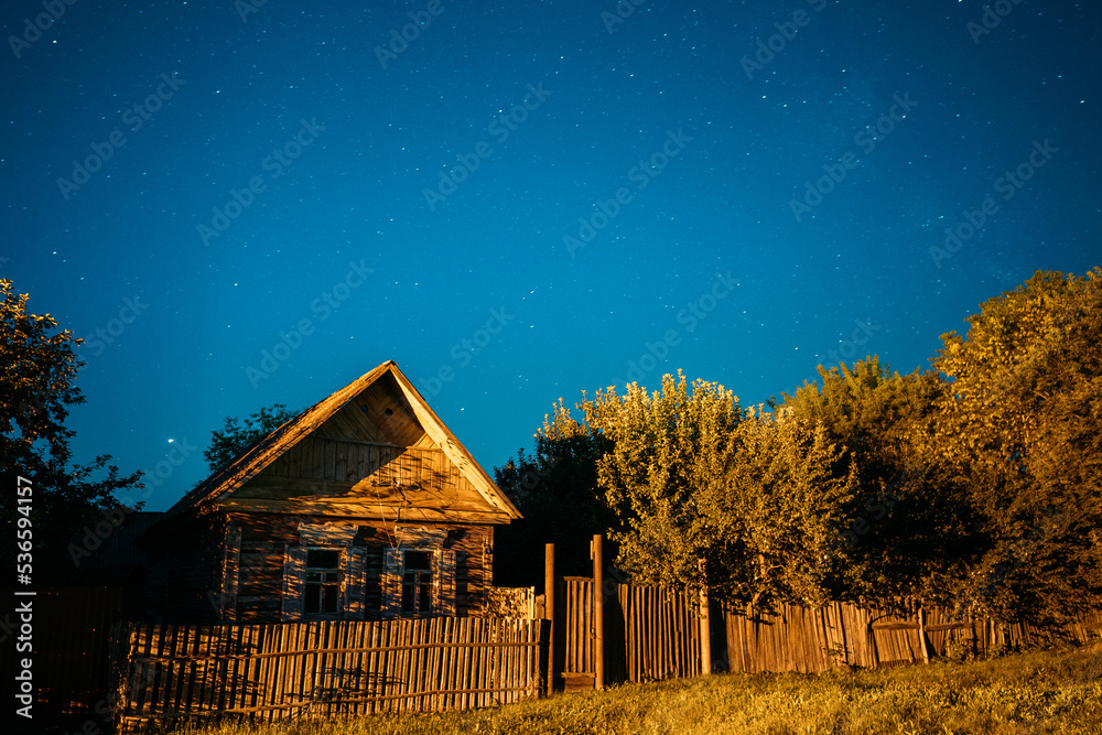 Night sky over old house in village. Night starry sky above house with ...
