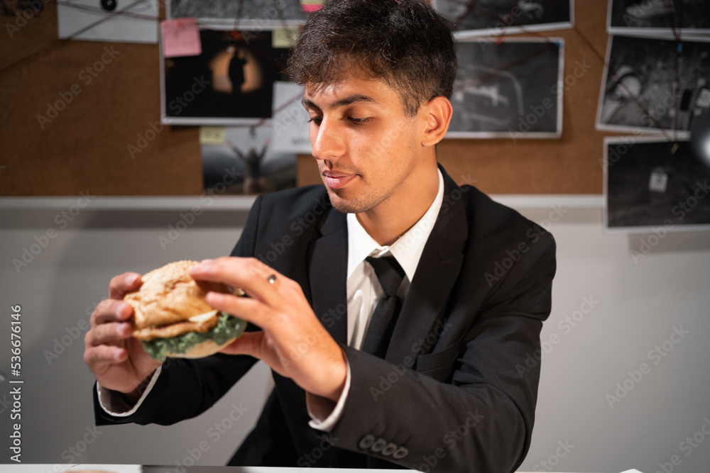 Detective eats junk hamburger at workplace, fast food in investigator ...