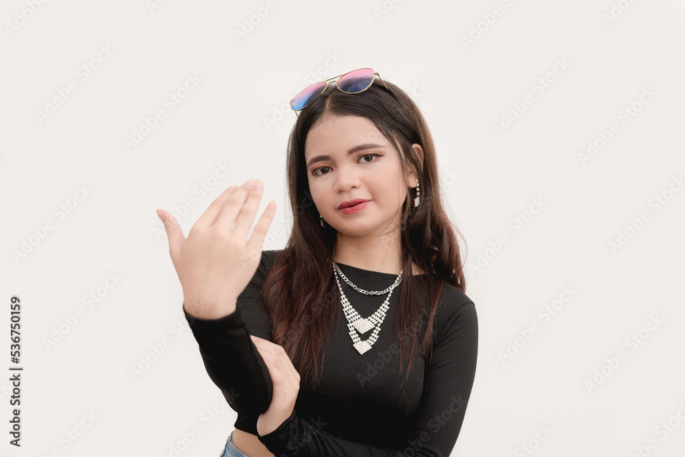 A young woman fanning herself with her hand as she poses for a studio ...