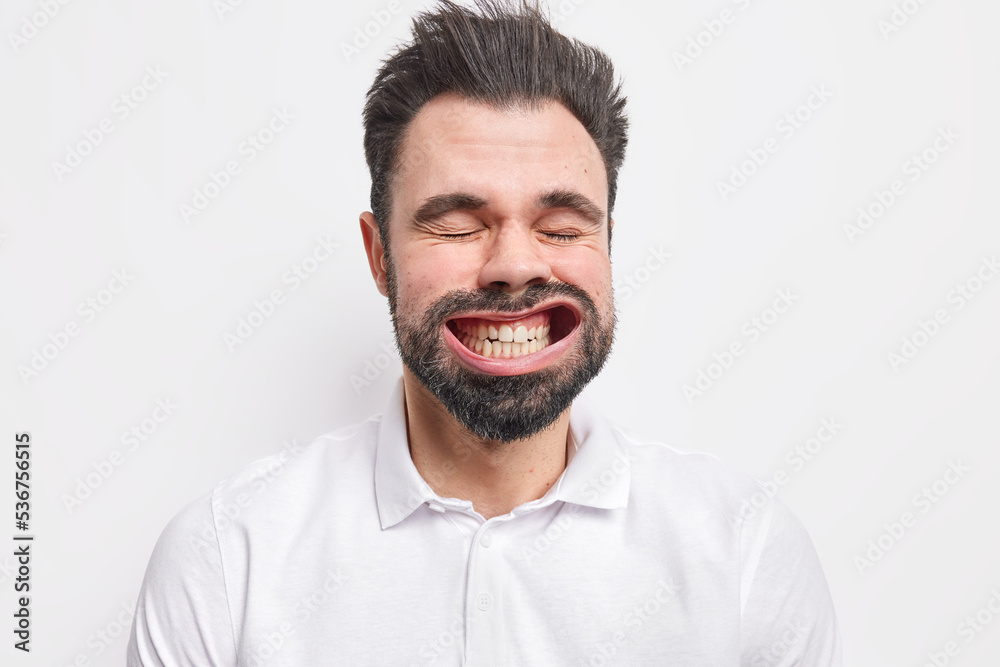 Close up portrait of handsome bearded dark haired man clenches teeth ...