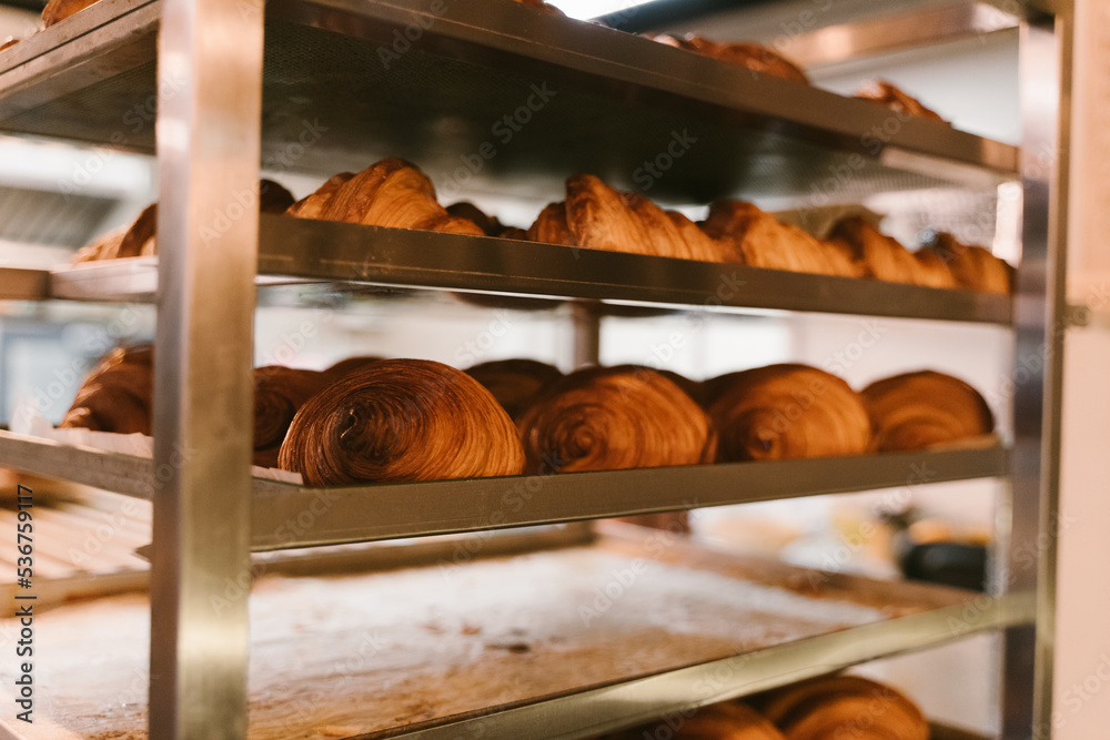Production of delicious buns. Family bakery. Hot croissants on a metal ...