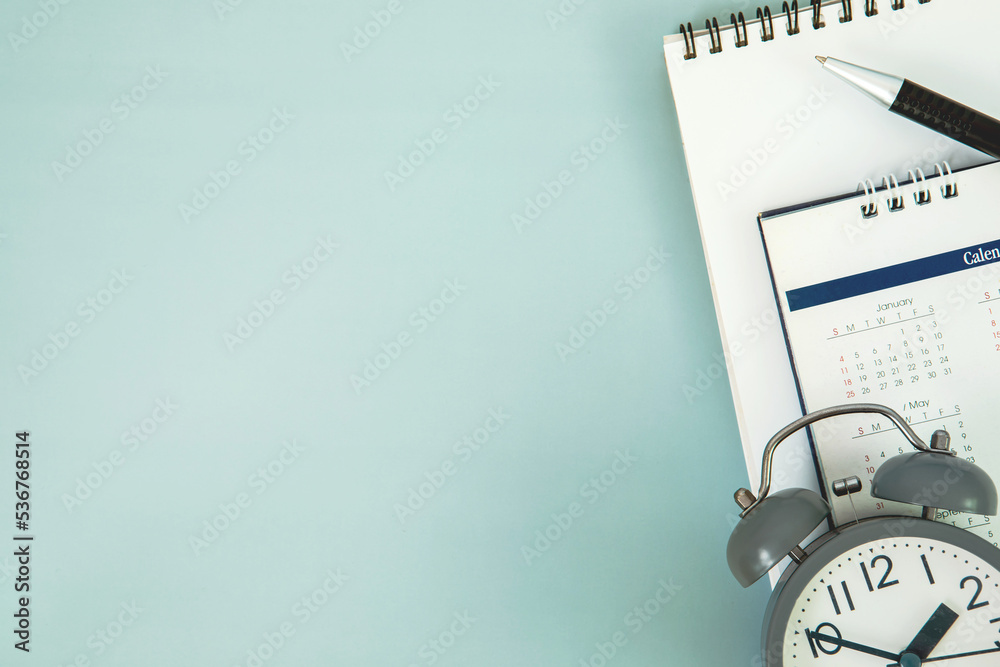 pen with white spiral notepad and alarm clock calendar , business ...