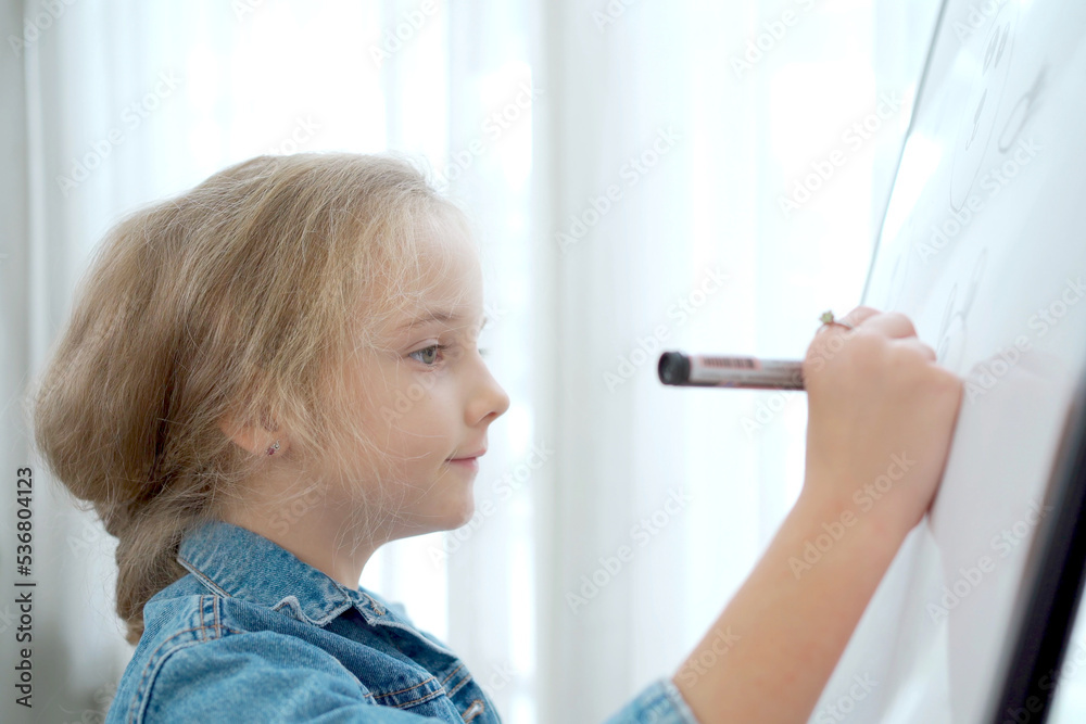 Lovely little cute girl enjoy drawing a picture and painting on a ...