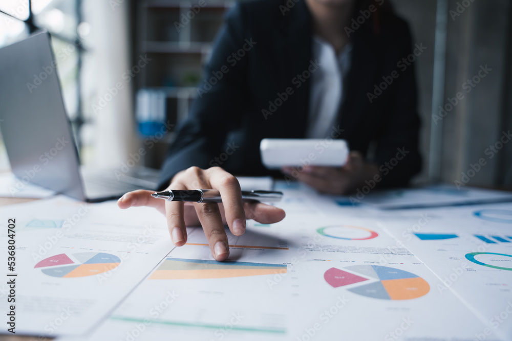 business people using calculator for calculating and pointing pen at ...