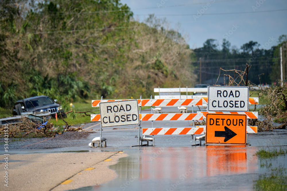 Hurricane Ian flooded street with road closed signs blocking driving of ...