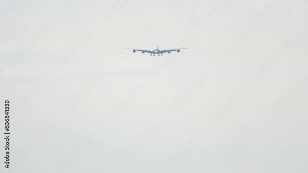 Widebody four-engine aircraft approaching landing, long shot. Airliner ...