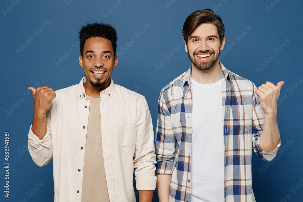 Young two friends men wear white casual shirts together point thumb ...