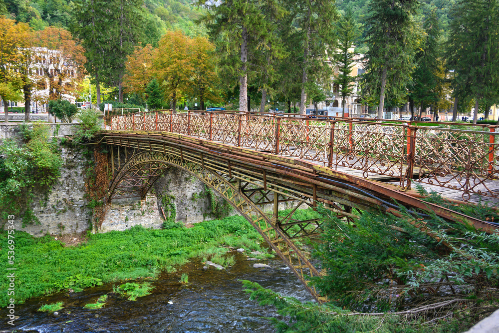 Old wrought iron bridge over the river that crosses the city. Old ...
