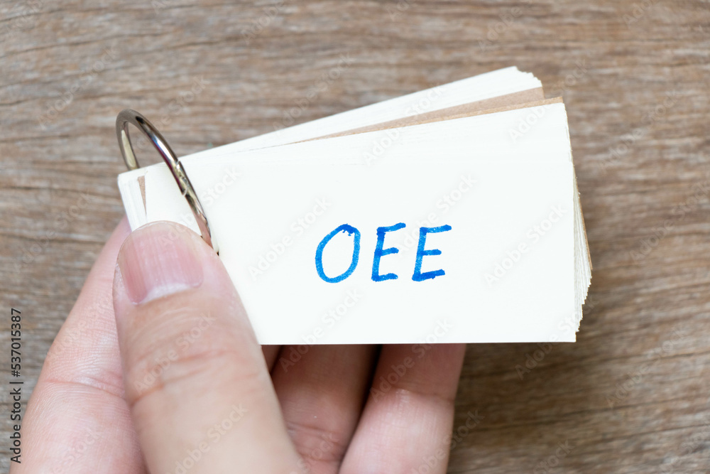 Hand hold flash card with handwriting in word OEE (abbreviation of ...