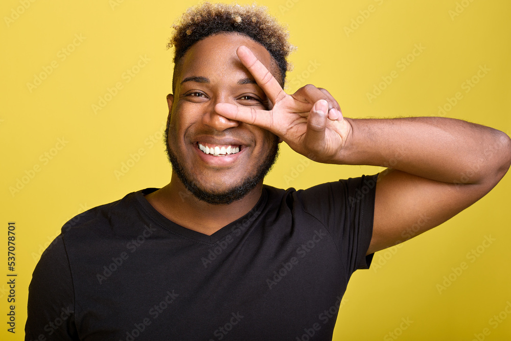 Smiling broadly African-American demonstrates peace and kindness around ...
