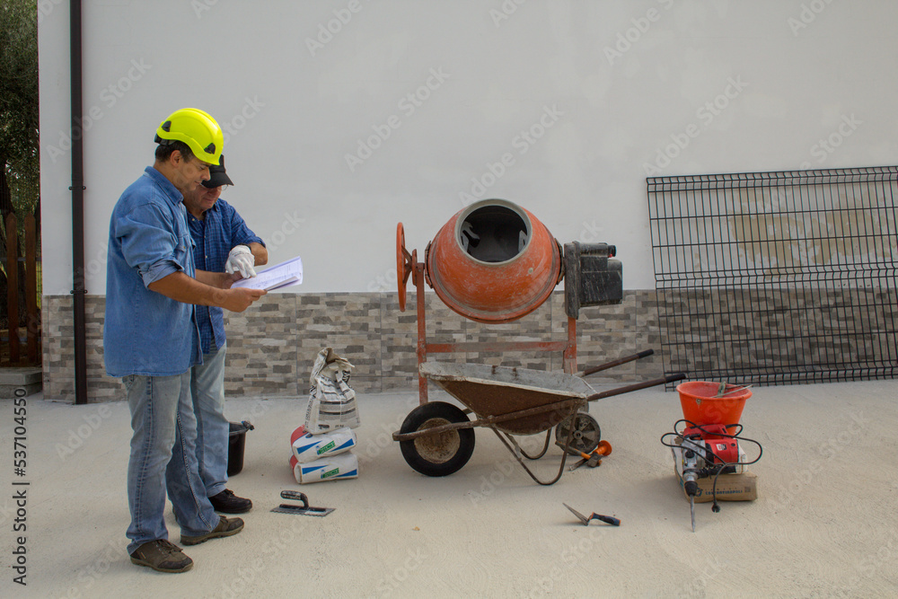 Image of two men an engineer and a construction worker consulting the ...