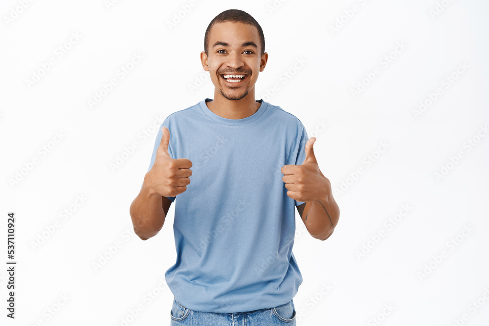 Smiling arab man shows thumbs up, recommends, gives positive feedback ...