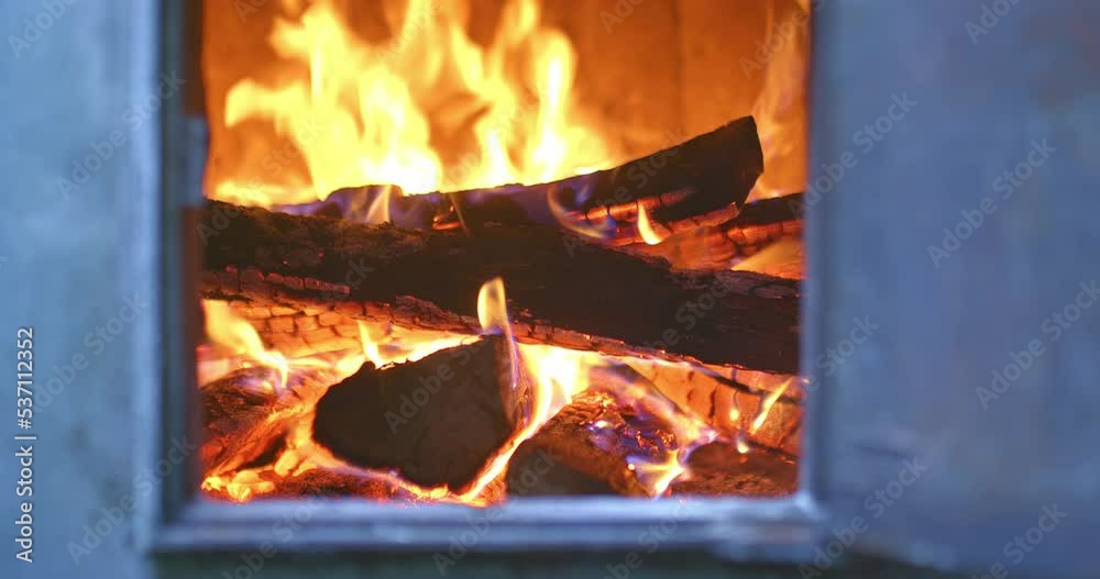 Logs are burning in the stove, red flames of fire. Firewood in a wood ...