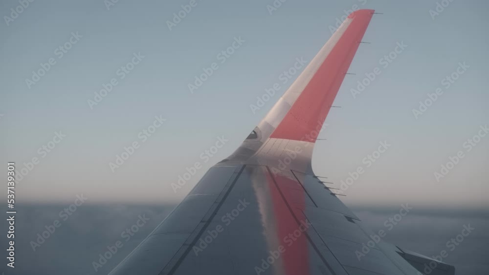 Aircraft curved wing in flight above clouds in sky. little turbulence ...