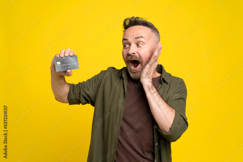 Shocked impressed handsome mature person hand hold debit card open ...