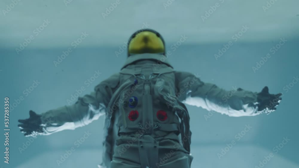 Astronaut spreading hands and falling into bright path or opened hatch ...