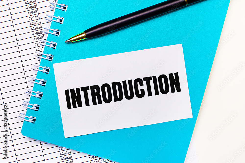 On the office desk there are reports, a blue notepad, a black pen, and ...