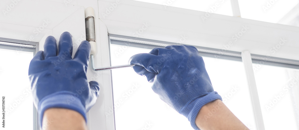 installation of plastic in a frame house, the builder screws the window ...