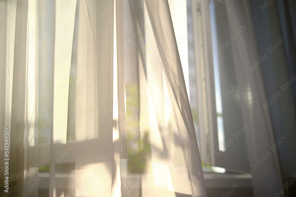 wind blows through the open window in the room. white curtain veil from ...