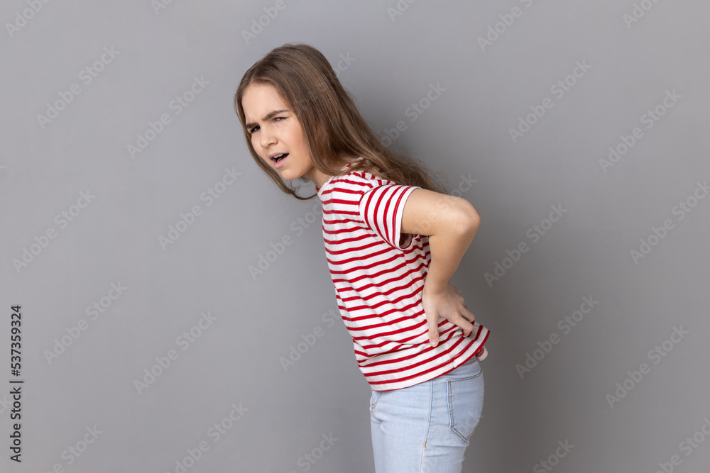 Side view portrait of little girl wearing striped T-shirt screaming in ...