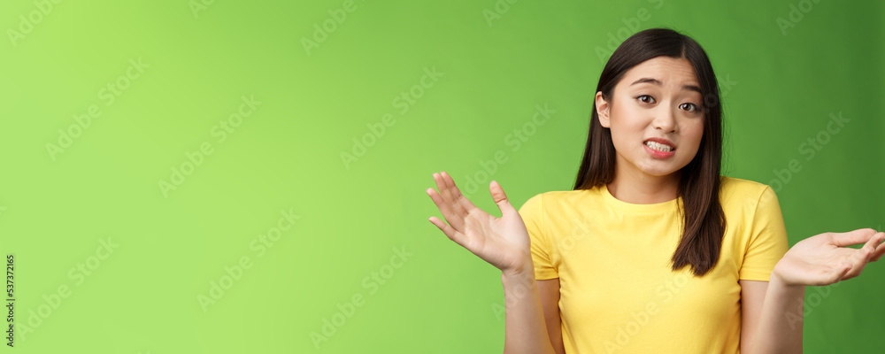 Confused cute apologizing asian girl shrugging hands spread sideways ...