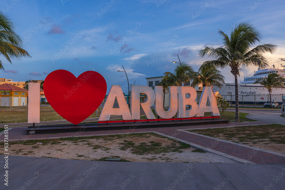 Beautiful sunset view with large white letters I love Aruba in center ...