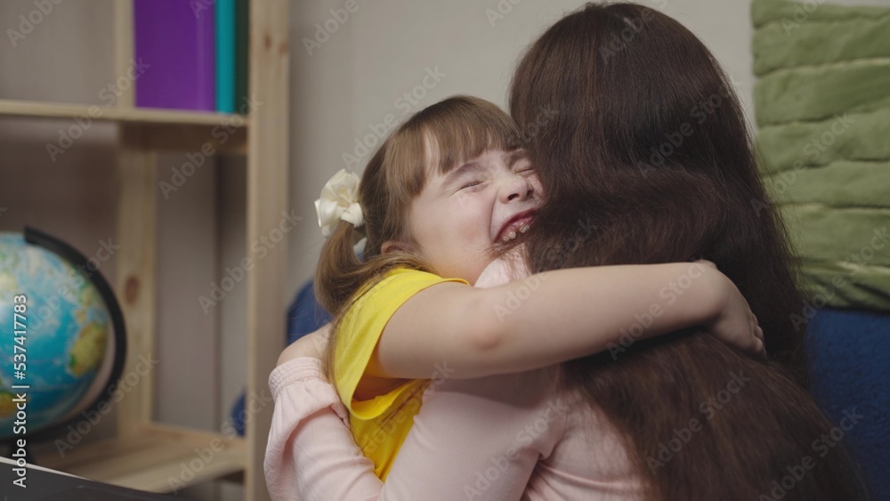 teamwork little cheerful girl does homework with her mother laptop ...