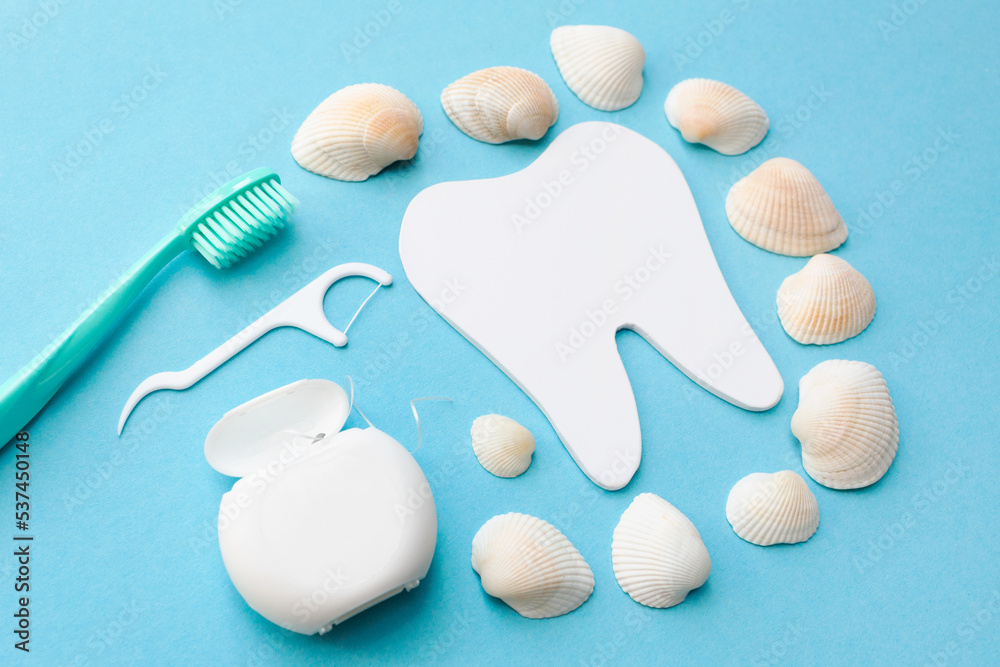 Tooth model with caries, toothbrush, dental floss and seashells. Blue ...