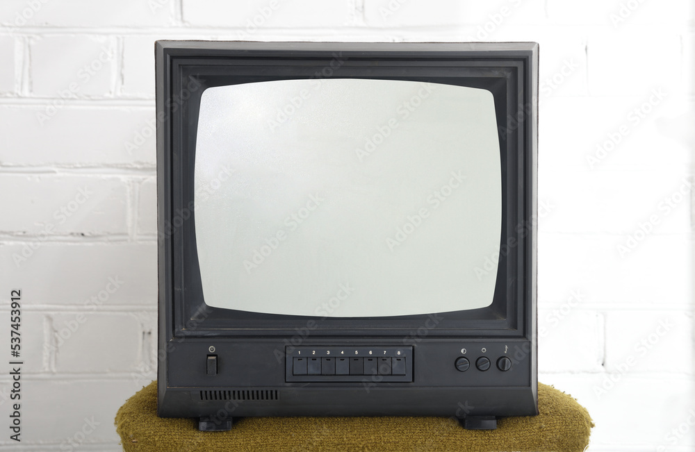Old black vintage TV set against a brick wall from the 1980s, 1990s ...
