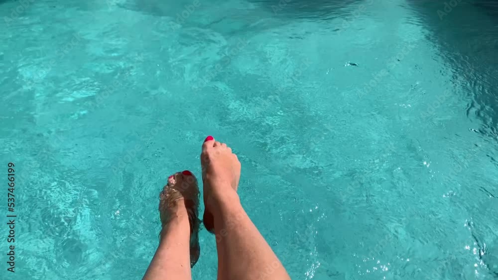 Beautiful sporty slim woman legs relaxing in water swimming pool spa ...