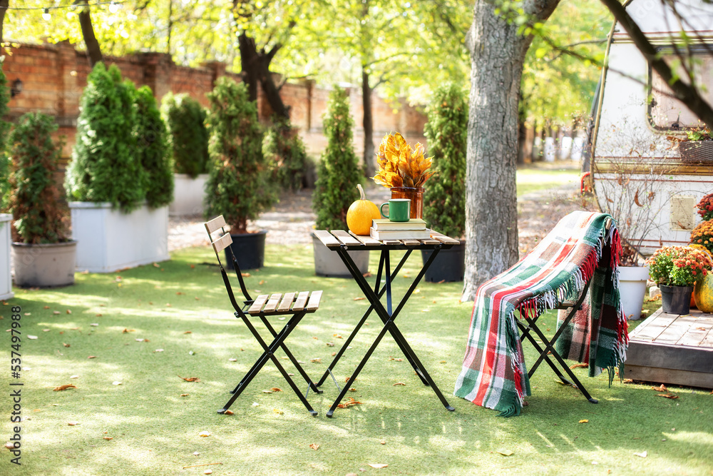Interior cozy campsite with flowers and pumpkins. Wooden RV house porch ...