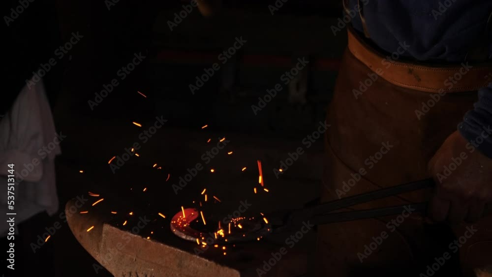 Close-up, Blacksmith cowboy man work, the horseshoe is worked on anvil ...