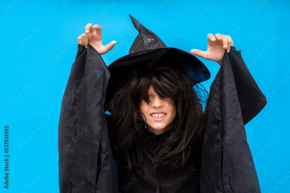 Happy Halloween kid raises his hands up while casting a spell. Child in ...