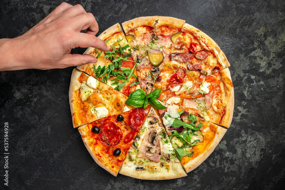 slices of pizza with different toppings, a hand holding a piece of ...