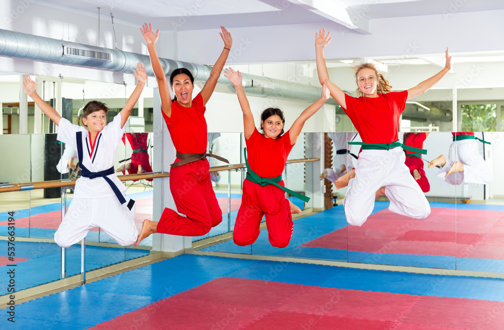 Happy kids and trainer in karate uniform jumping together in gym. Stock ...