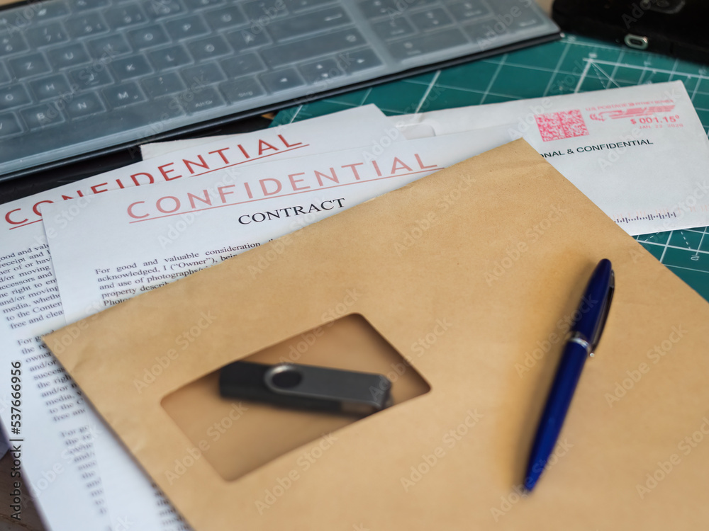 Opened letter with confidential papers and pen as a symbol for a secret ...
