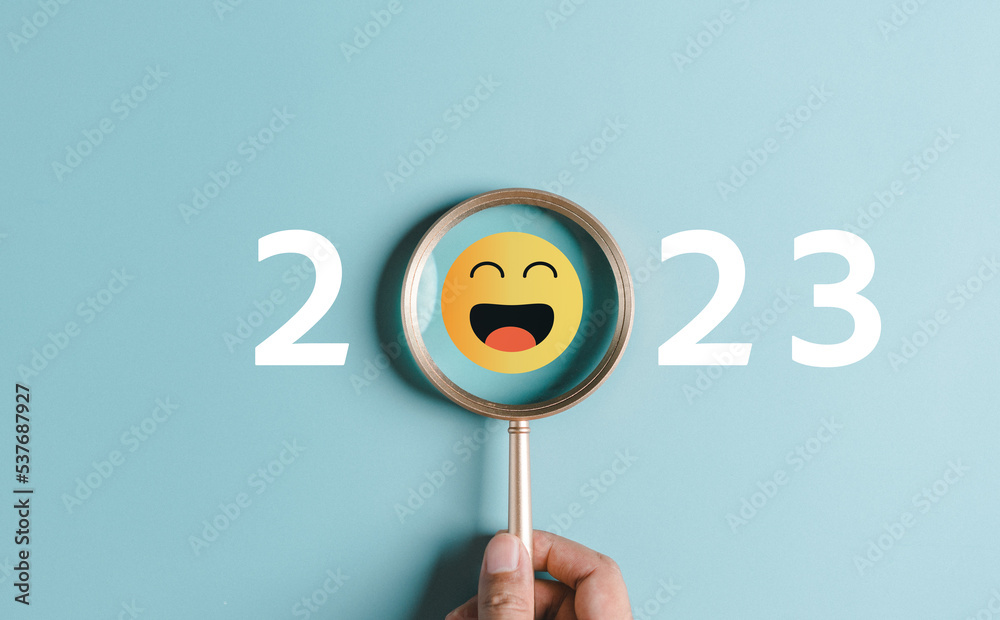 Smiley face on 2023 year concept. Magnifier focus to yellow emoticon ...