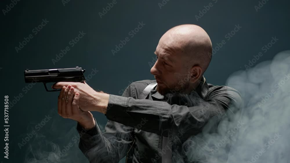 Police detective holds service pistol gun in his hand and aims at the ...